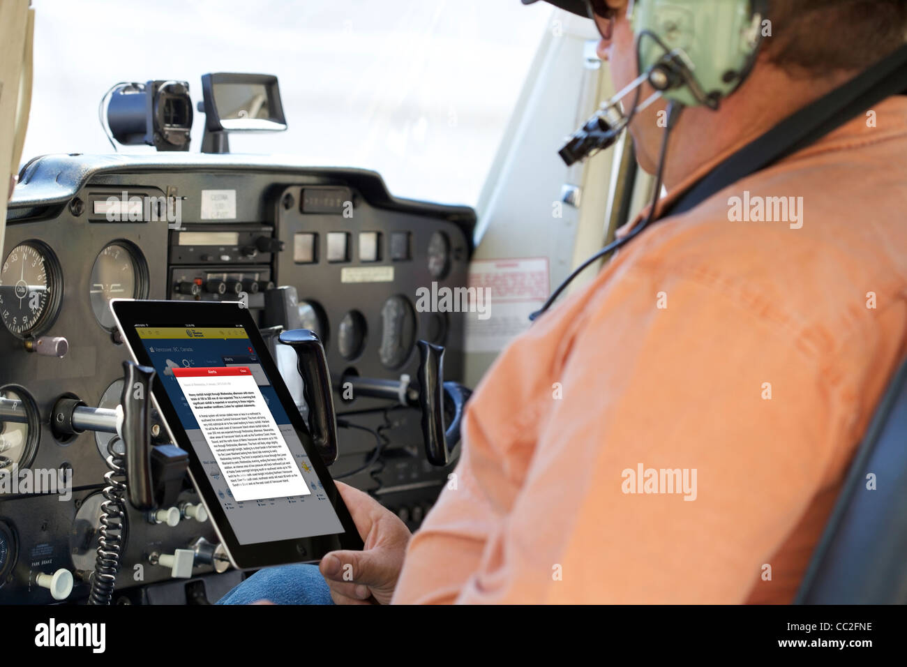 Private airplane pilot reading warning information on his ipad with ...