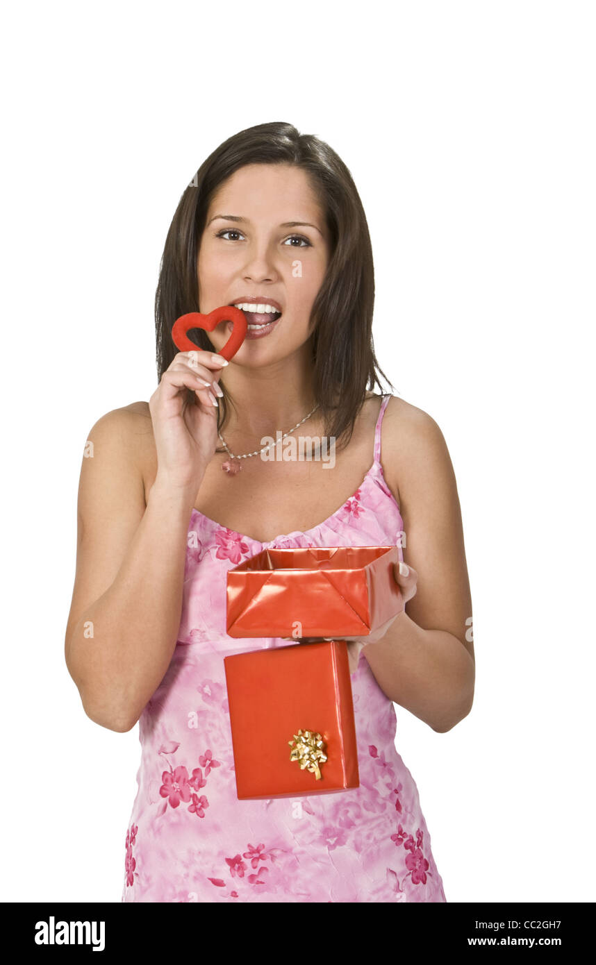 Beautiful brunette biting into a red heart Stock Photo - Alamy