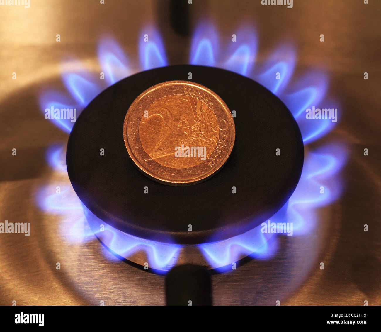 A two 2 euro euros coin sitting on a natural gas burner cooker stove ...