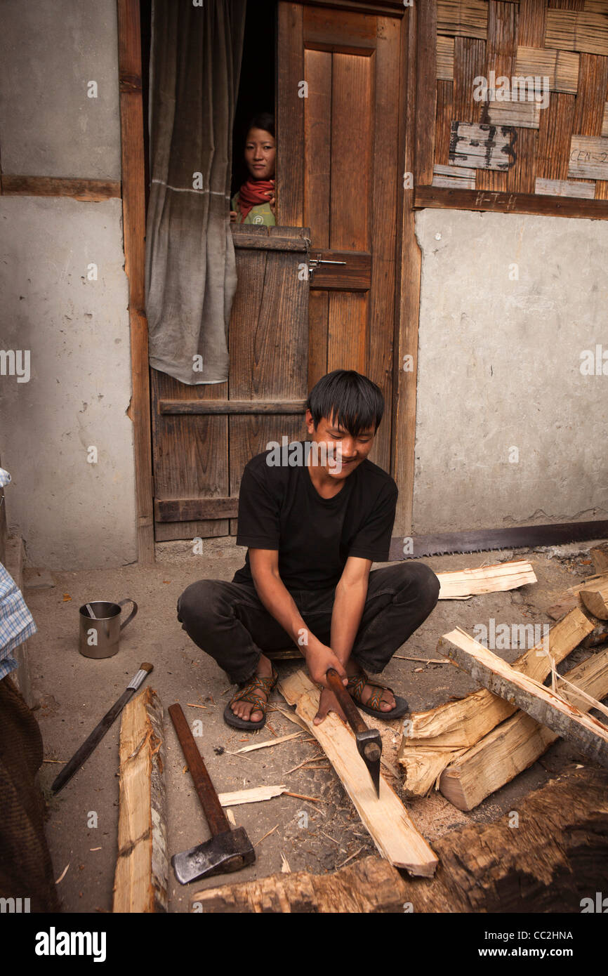 India, Arunachal Pradesh, Old Ziro village man cutting firewood with ...