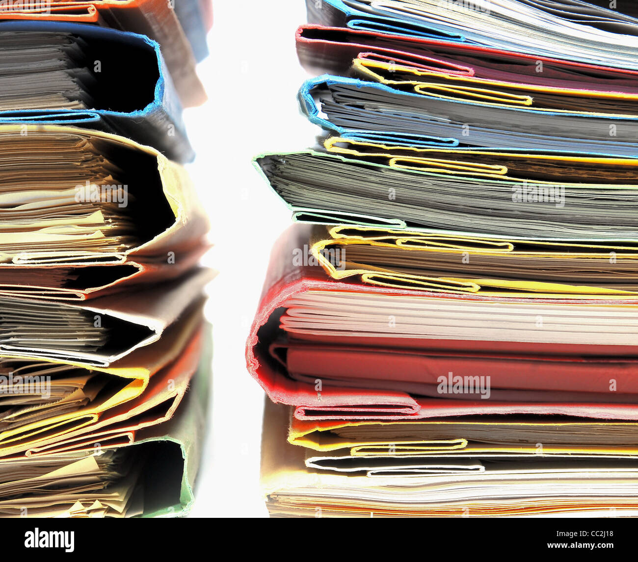 Two piles of colorful folders over white background Stock Photo - Alamy