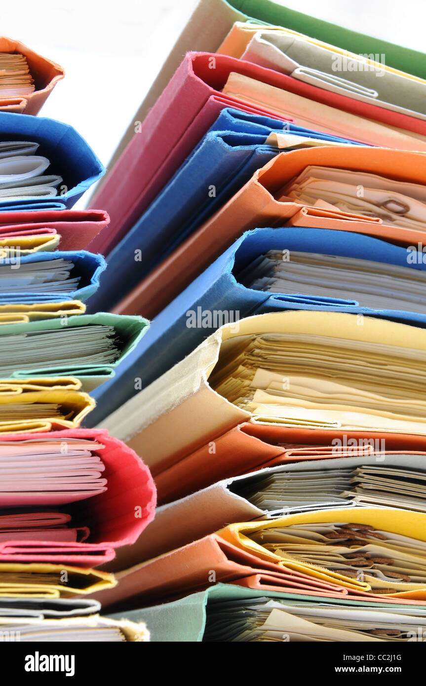 Two piles of colorful folders over white background Stock Photo - Alamy