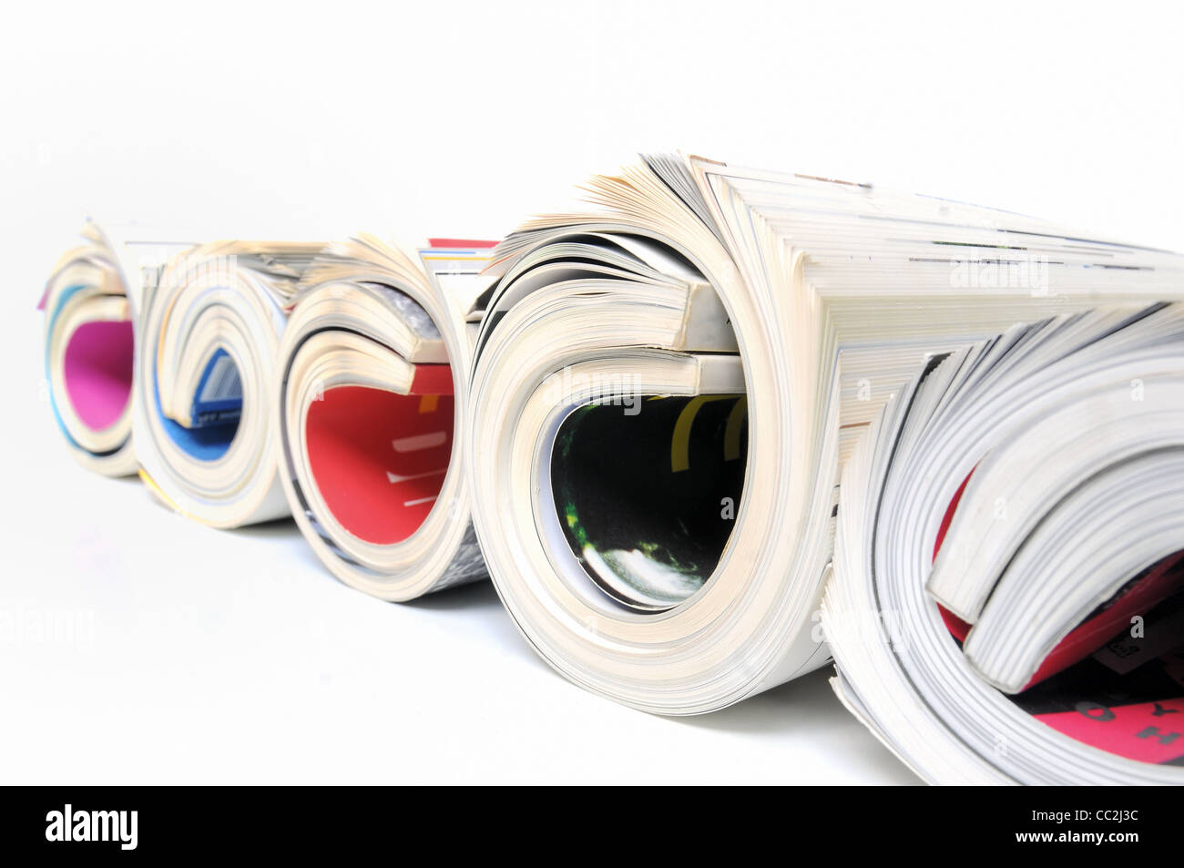 Rolled up magazines over white background Stock Photo - Alamy