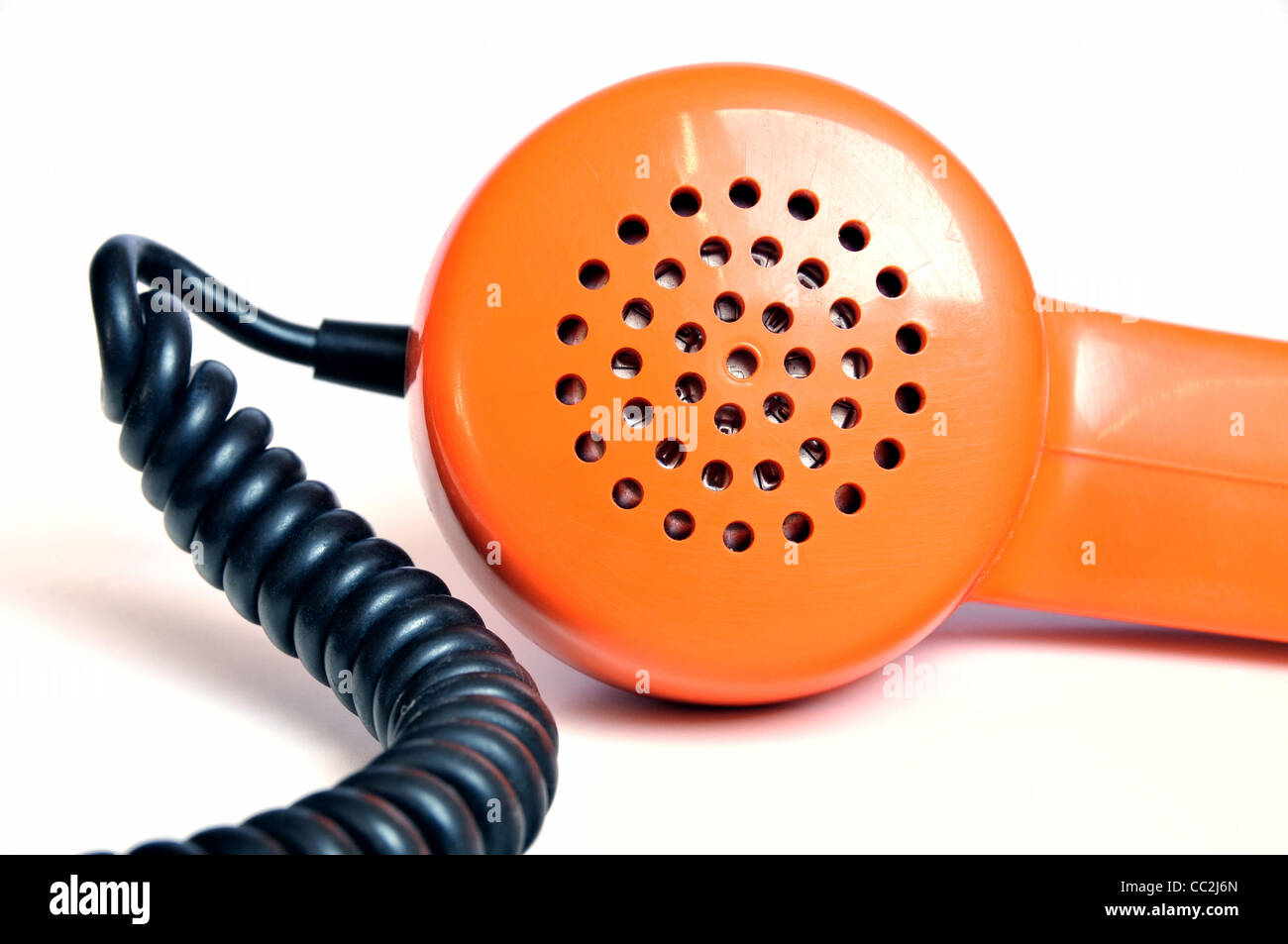 Old fashioned orange colored retro telephone over white background ...