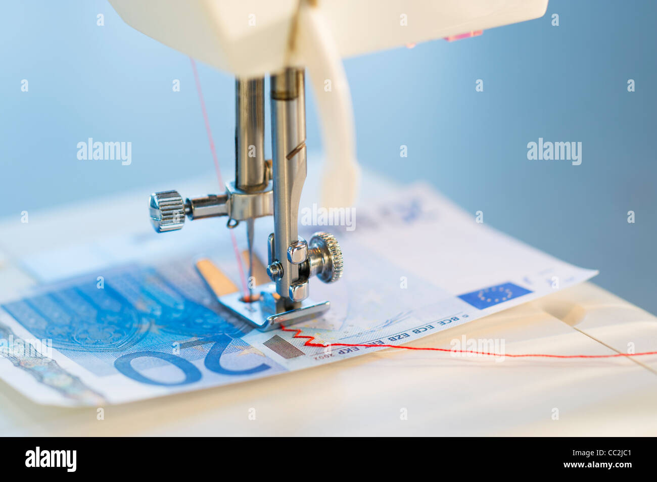 Sewing machine stitching 20 euro note, studio shot Stock Photo - Alamy