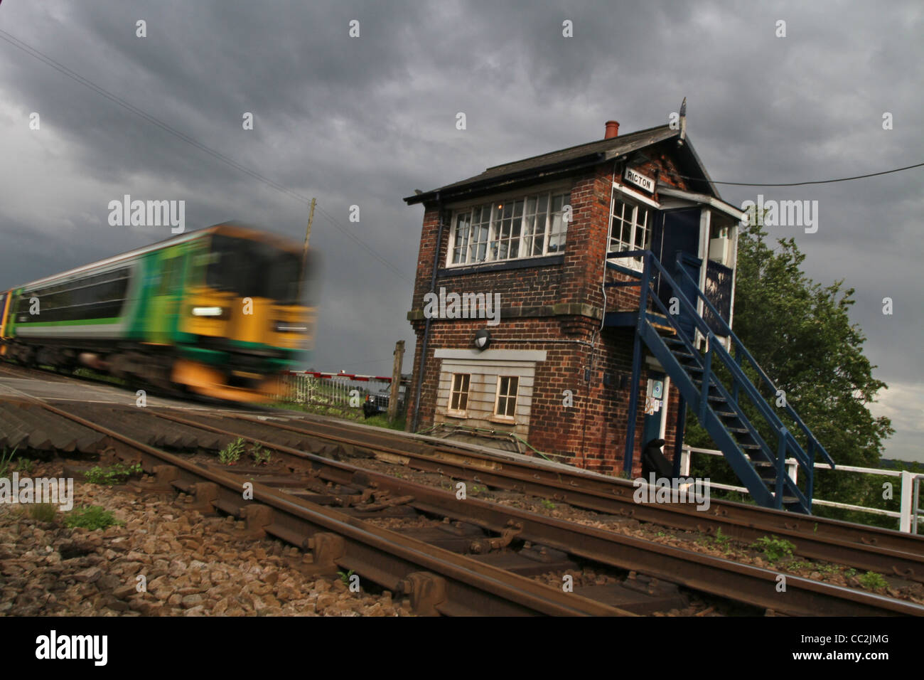 speeding train passing through a level crossing Stock Photo - Alamy
