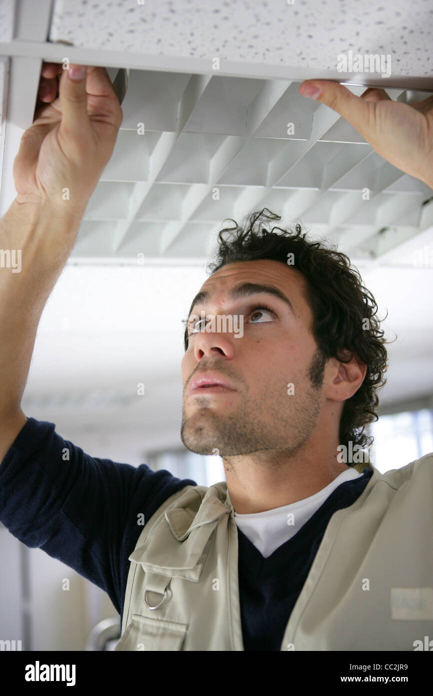 Man putting up a suspended ceiling Stock Photo - Alamy