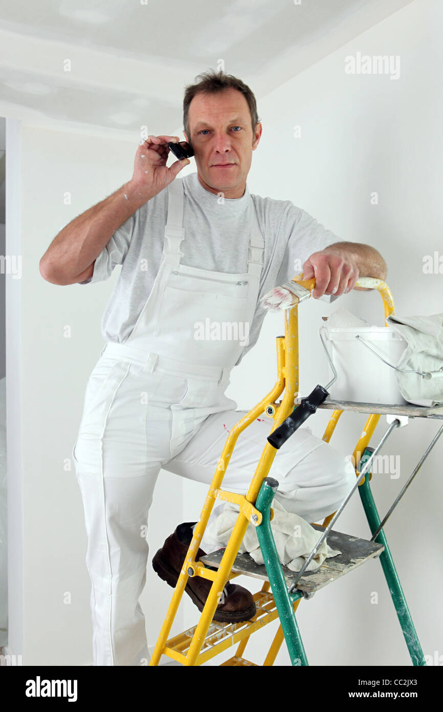 Painter making a call from top of ladder Stock Photo - Alamy