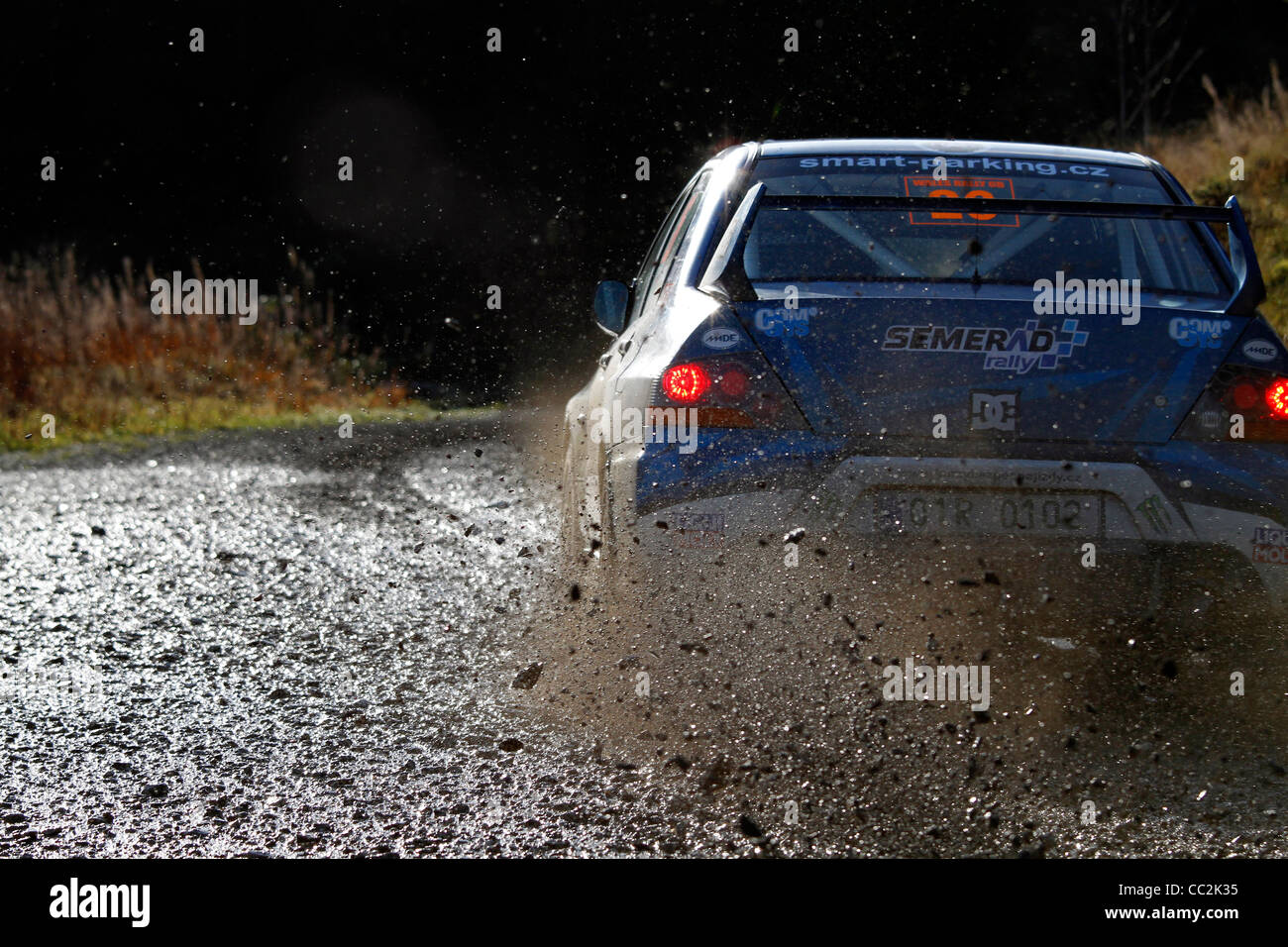 gravel sprays from a rally cars wheels as it passes Stock Photo - Alamy