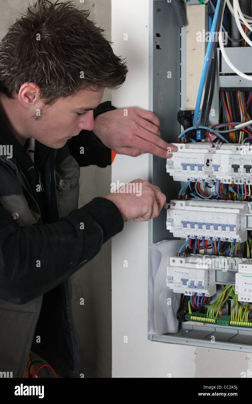 Electrician checking a distribution board Stock Photo - Alamy