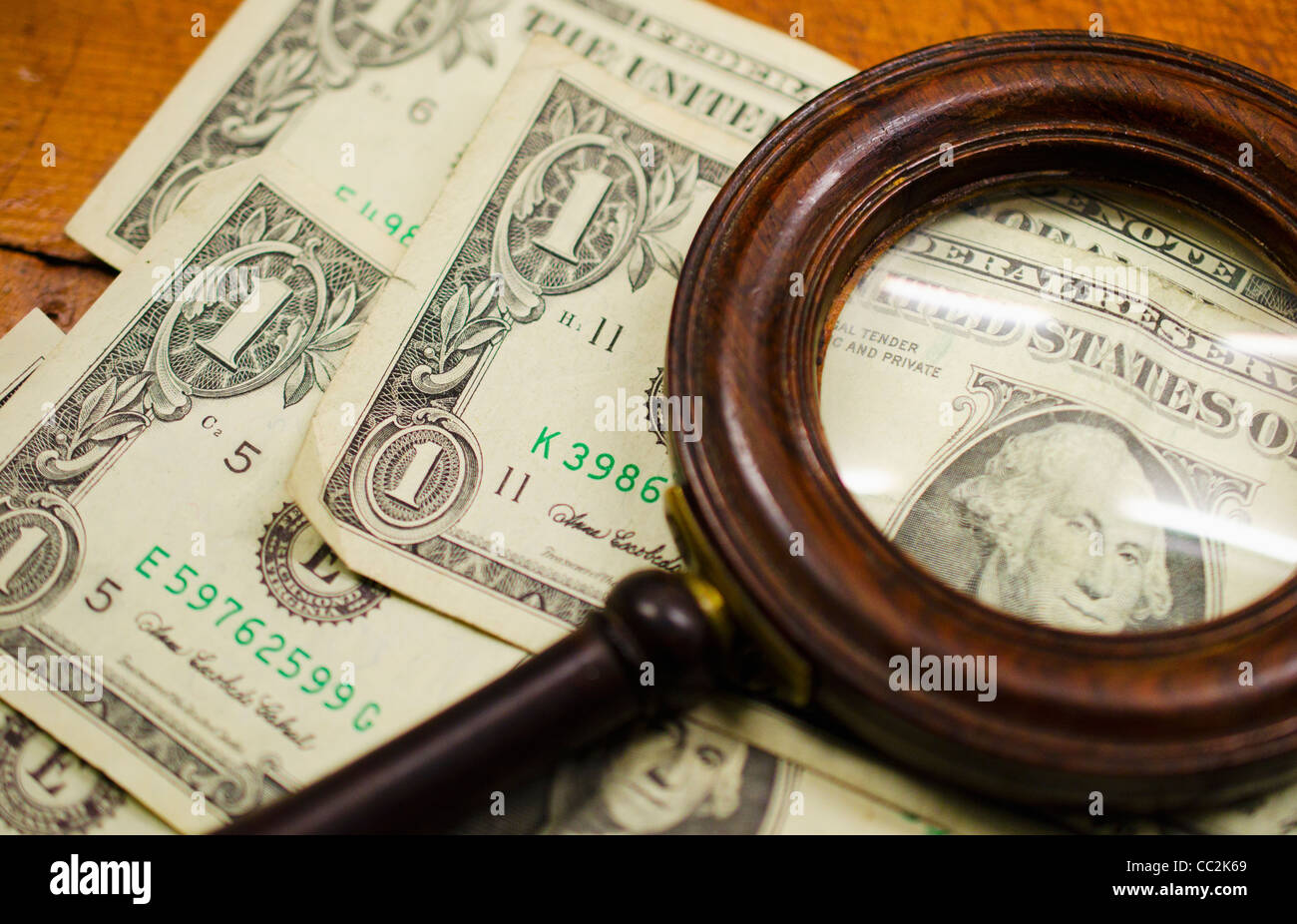 Dollar bills with magnifying glass, studio shot Stock Photo - Alamy