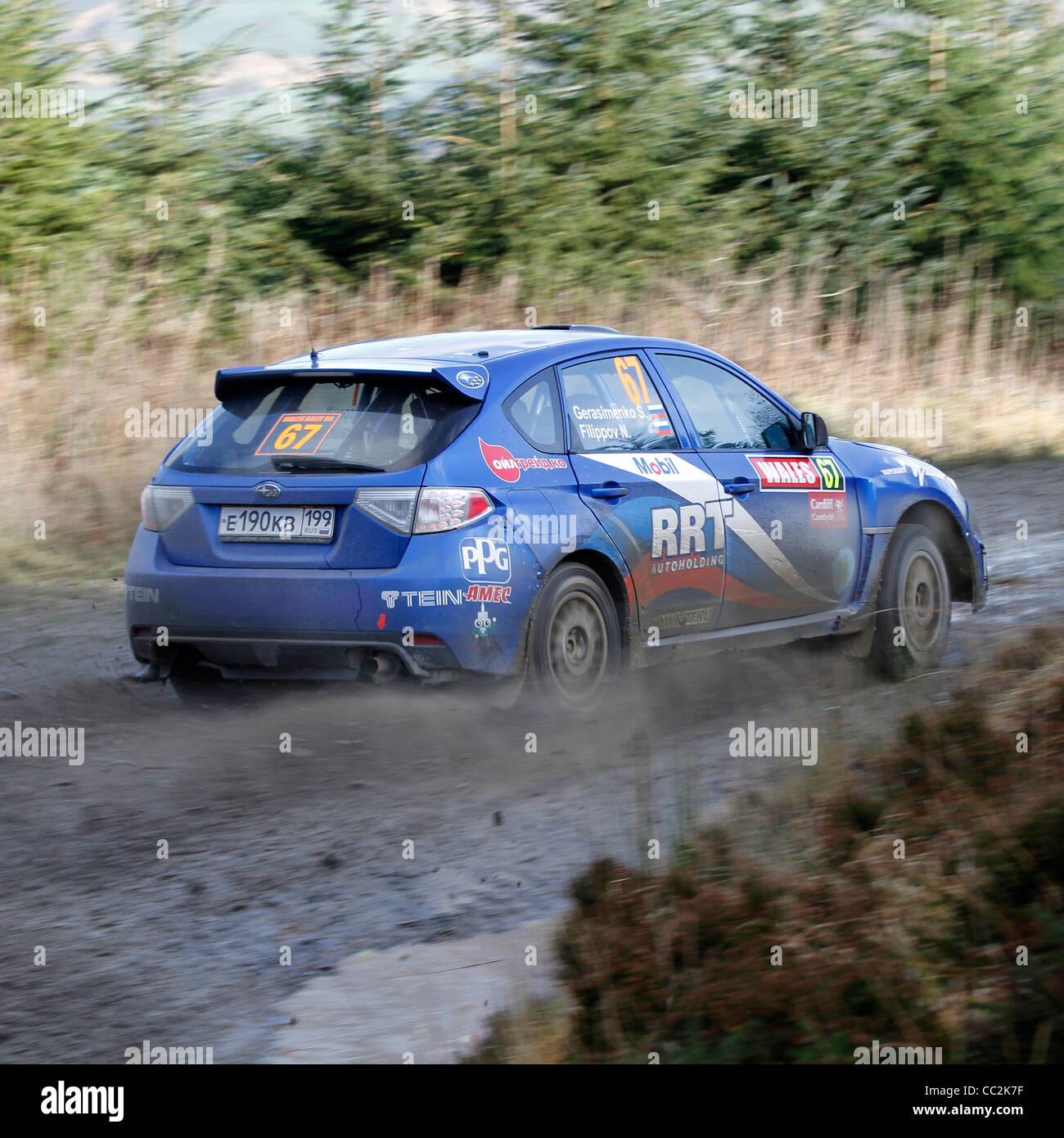 gravel sprays from a rally cars wheels as it passes Stock Photo - Alamy
