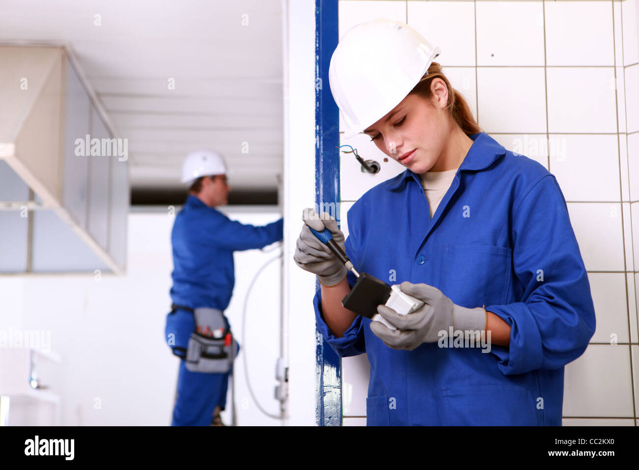 Male and female electricians working together Stock Photo - Alamy