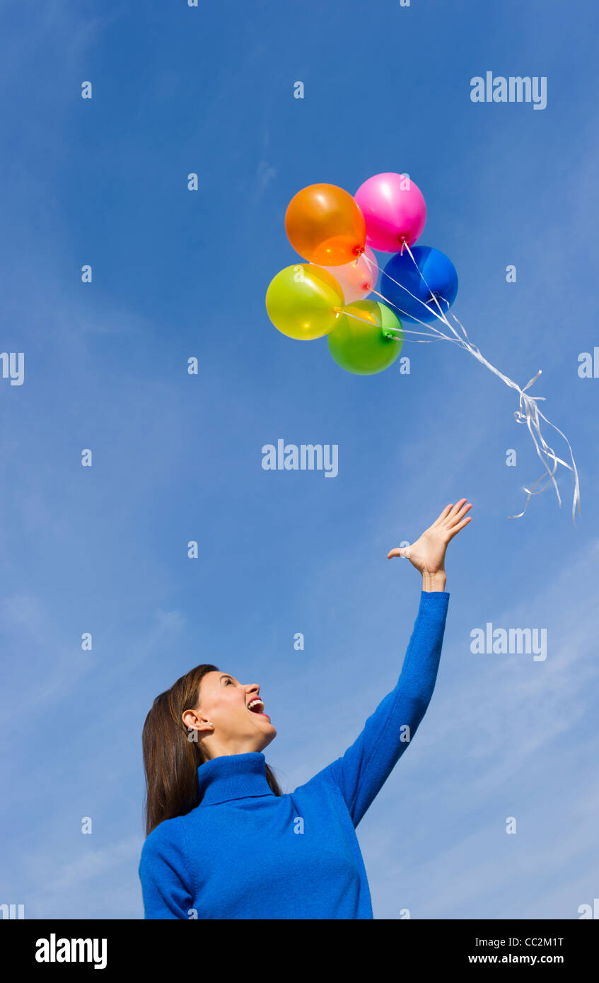 USA, New Jersey, Jersey City, Smiling woman loosing balloons Stock ...