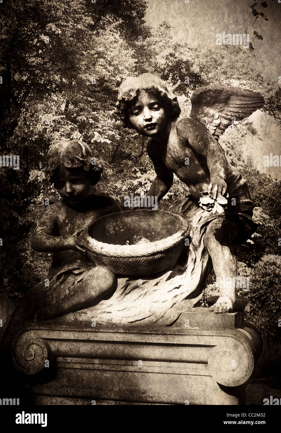 Two statues of young boy angels in Brompton Cemetery, London Stock ...