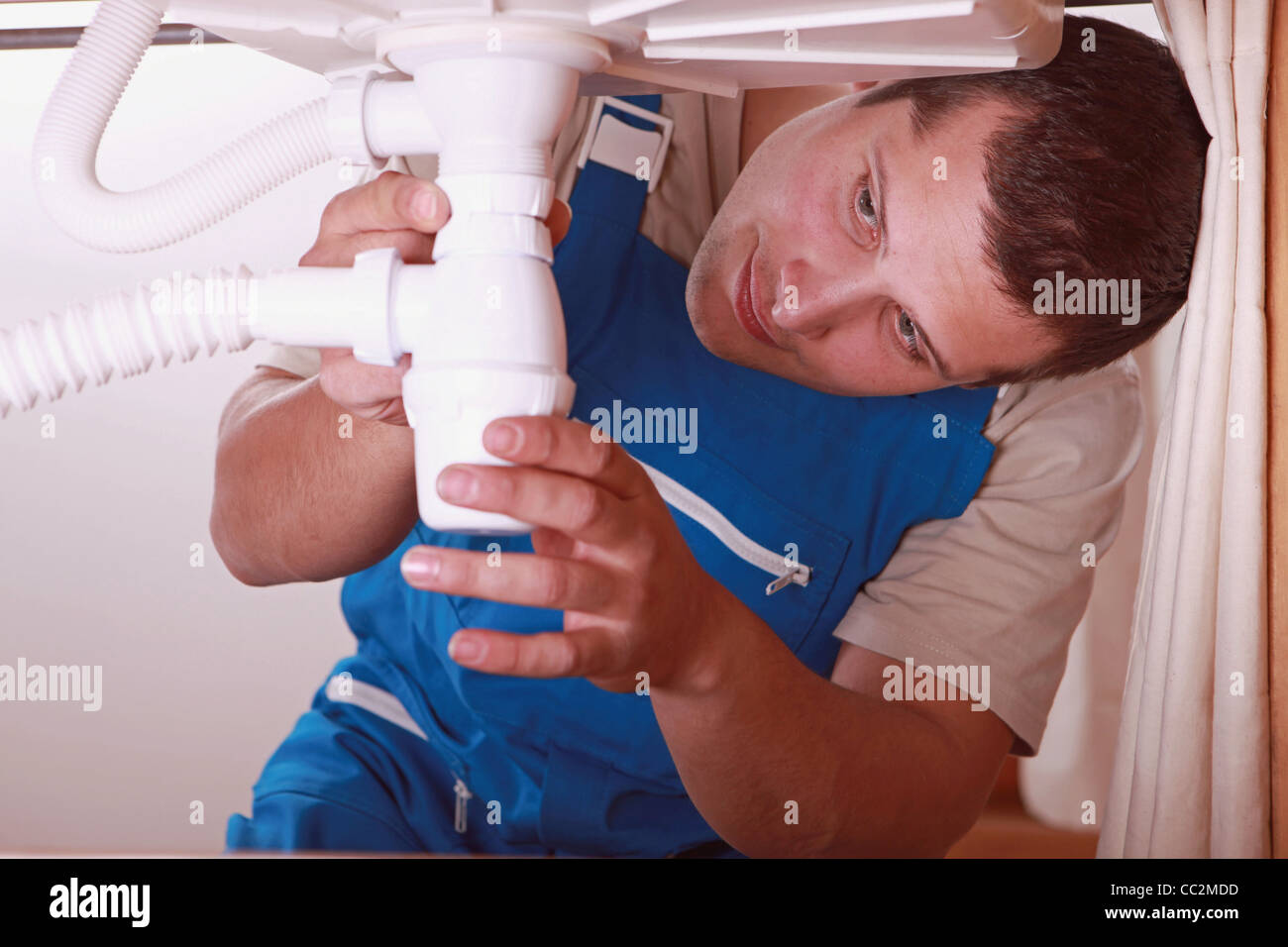 Male plumber connecting pipes Stock Photo - Alamy