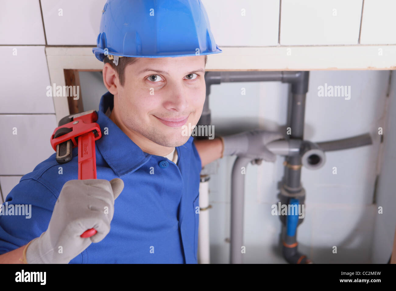 Handsome young plumber with a wrench Stock Photo - Alamy