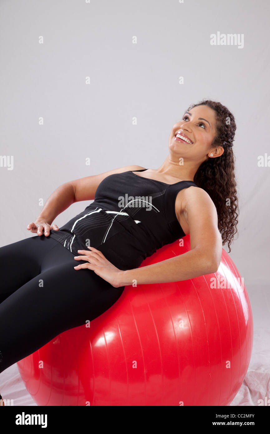 Lovely Caucasian woman in a black exercise suit, smiling with pleasure ...