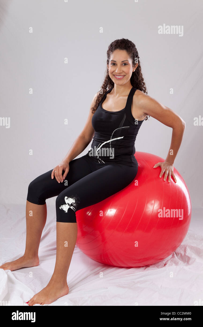 Lovely Caucasian woman in a black exercise suit, smiling with pleasure ...