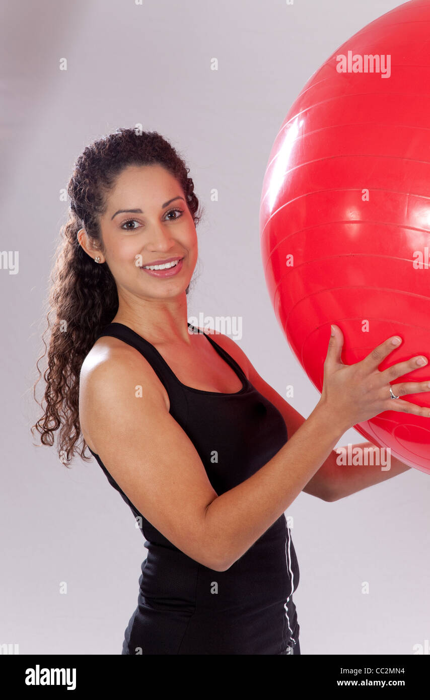 Lovely Caucasian woman in a black exercise suit, smiling with pleasure ...