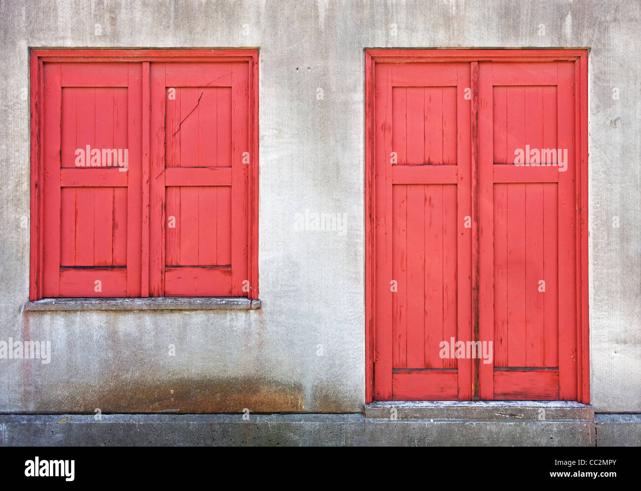 red door and window shutters on concrete wall Stock Photo - Alamy