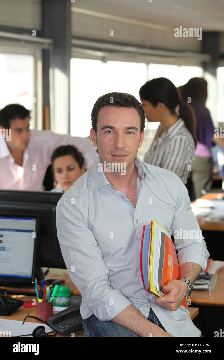 Man sitting on a desk with files Stock Photo - Alamy