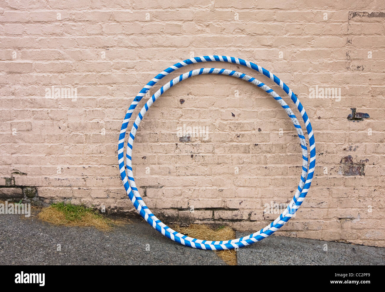 two blue and white hula hoops resting against painted brick wall Stock ...