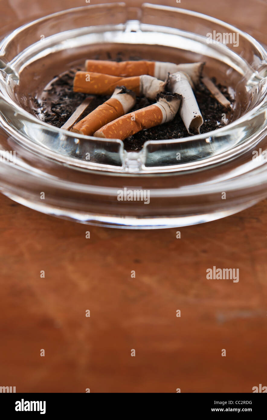 Close up of cigarette butts in glass ashtray Stock Photo - Alamy