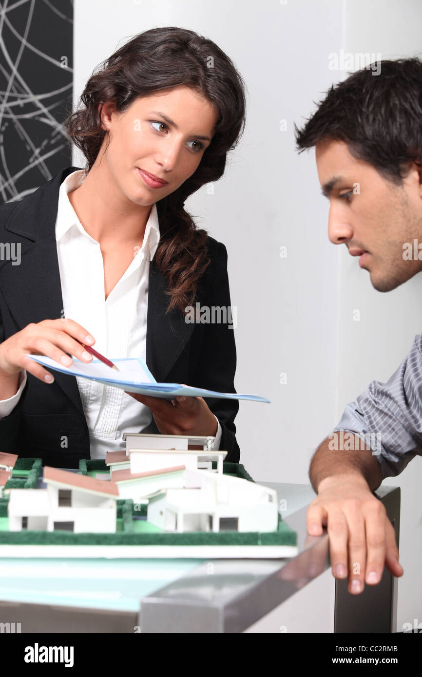 Estate agent and client discussing contracts Stock Photo - Alamy