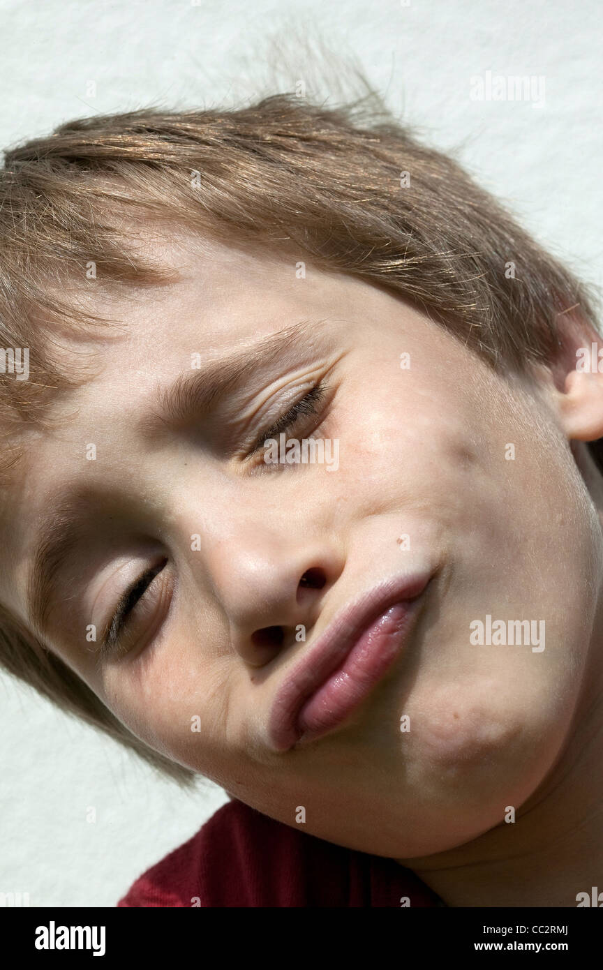 Close-up on young boy making faces at camera Stock Photo - Alamy
