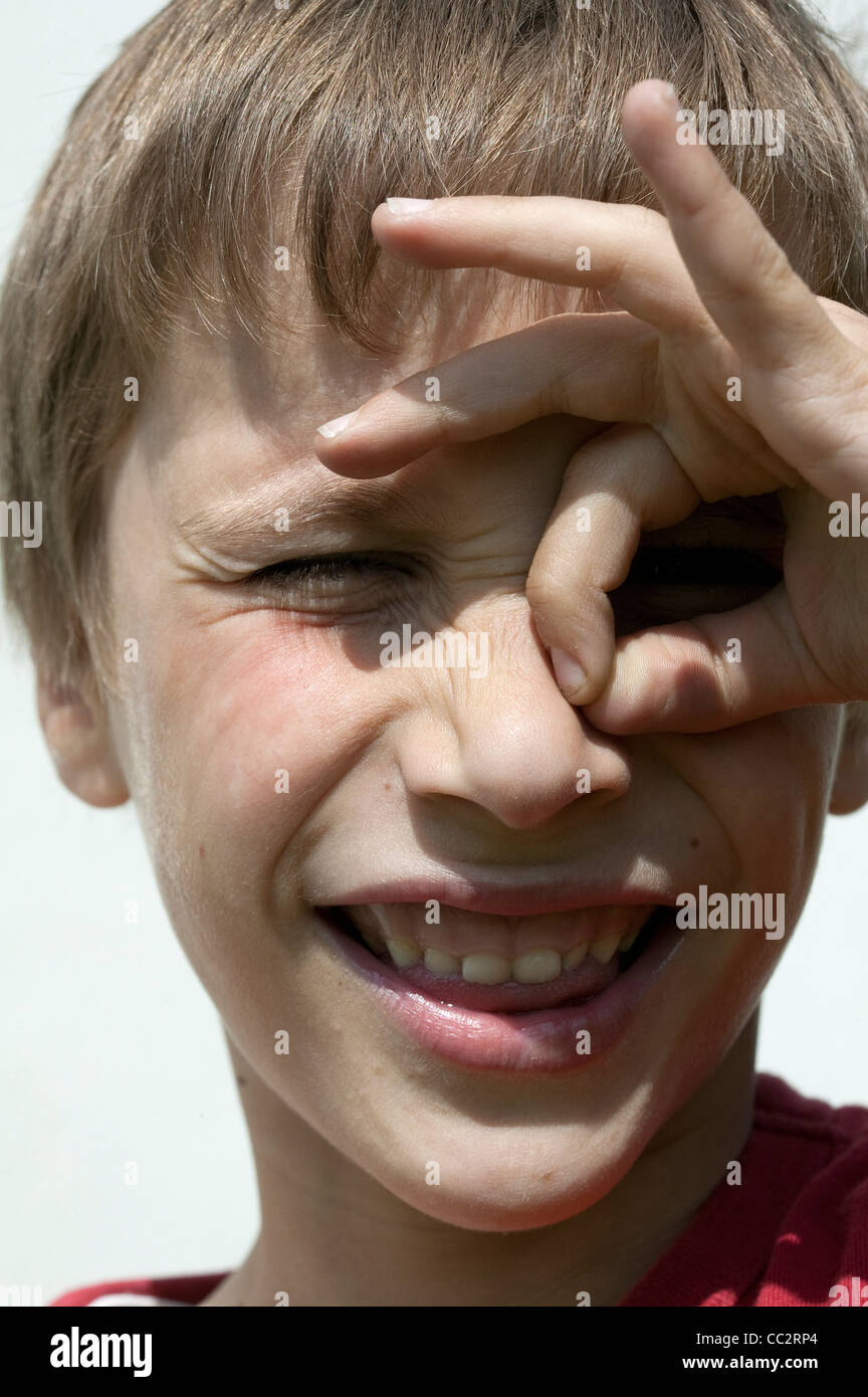Close-up on young boy making faces at camera Stock Photo - Alamy