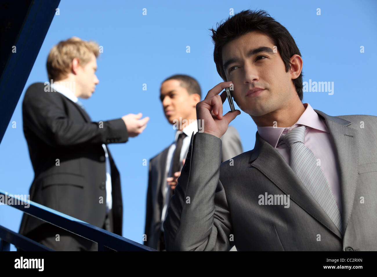 Three businessmen stood outside building Stock Photo - Alamy