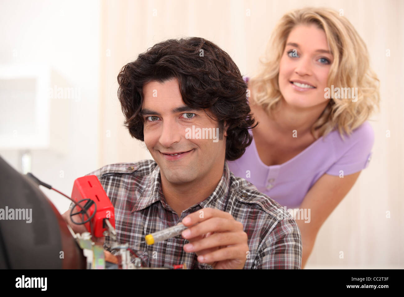Couple repairing old television Stock Photo - Alamy