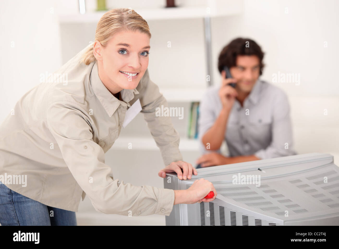 Woman fixing a television set Stock Photo - Alamy