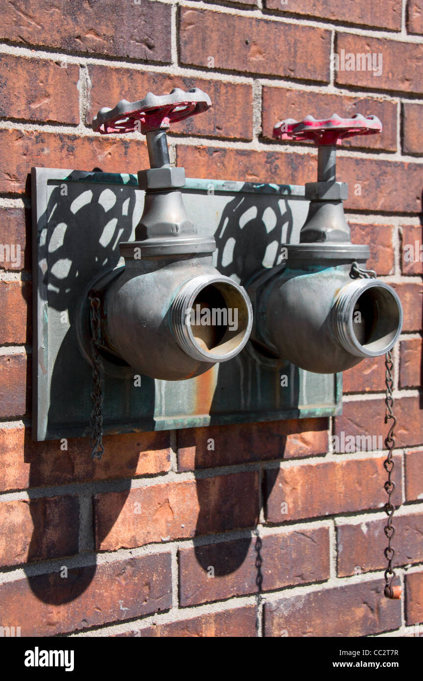 Old copper hydrant with two valve with rust and verdigris against a ...