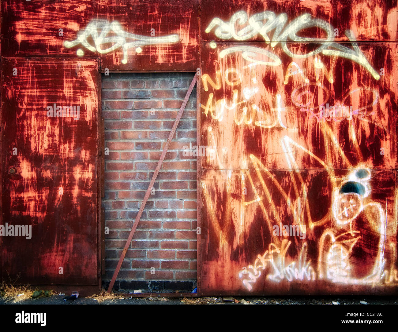 Filled in derelict door with red brickwork and graffiti Stock Photo - Alamy