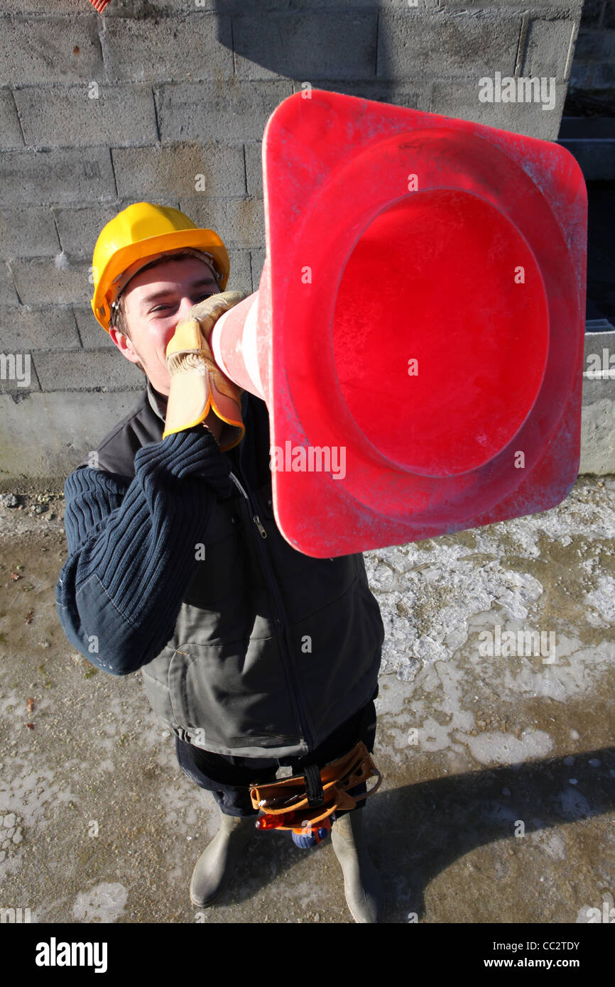 Builder shouting through traffic cone Stock Photo - Alamy