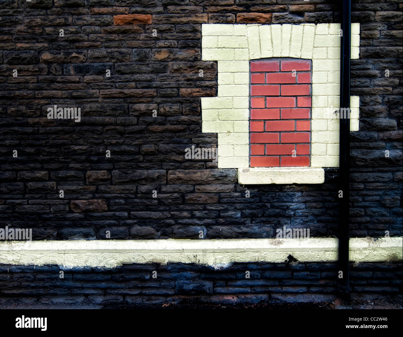 Derelict bricked in window with drainpipe Stock Photo - Alamy