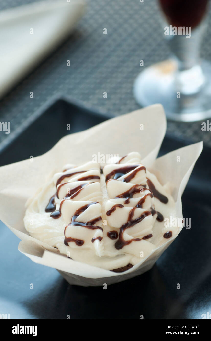 Classy buttercream frosting covered cupcake with chocolate syrup ...