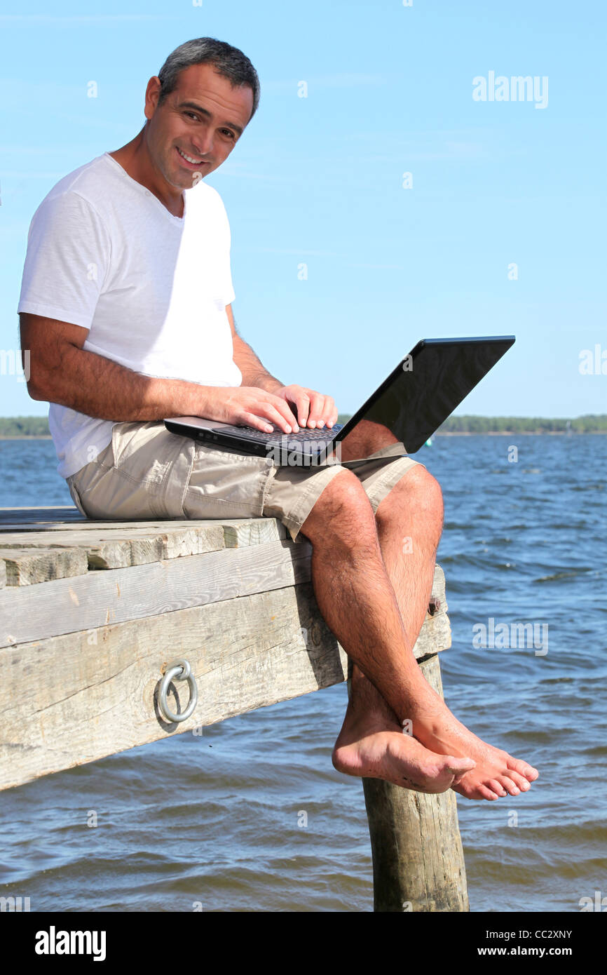 man with a laptop on holidays Stock Photo - Alamy