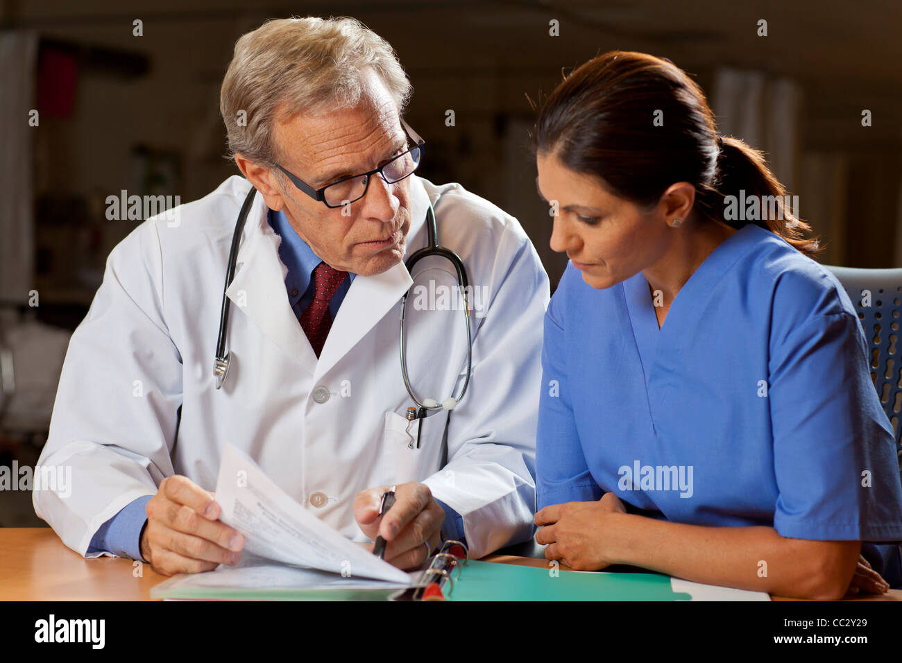 USA, Arizona, Phoenix, Doctors sitting at desk and reading files Stock ...