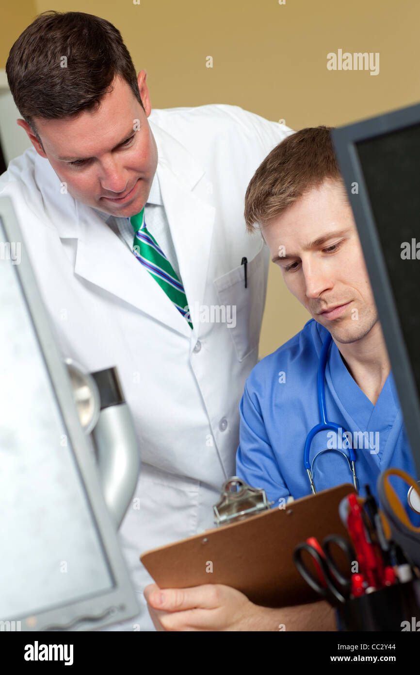 USA, Arizona, Phoenix, Doctor and surgeon reading medical record in ...