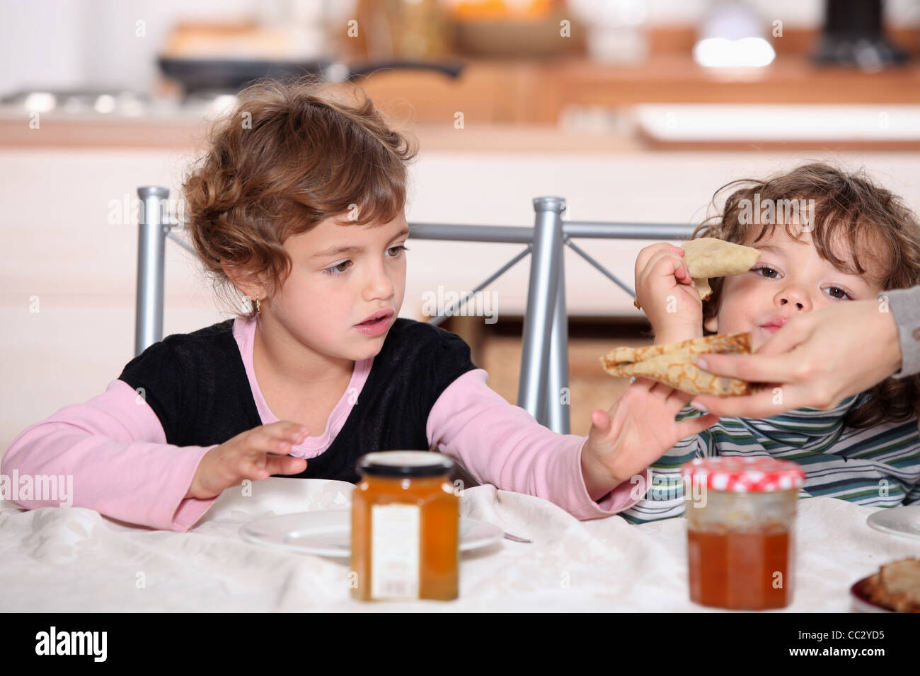 Two children eating breakfast Stock Photo - Alamy
