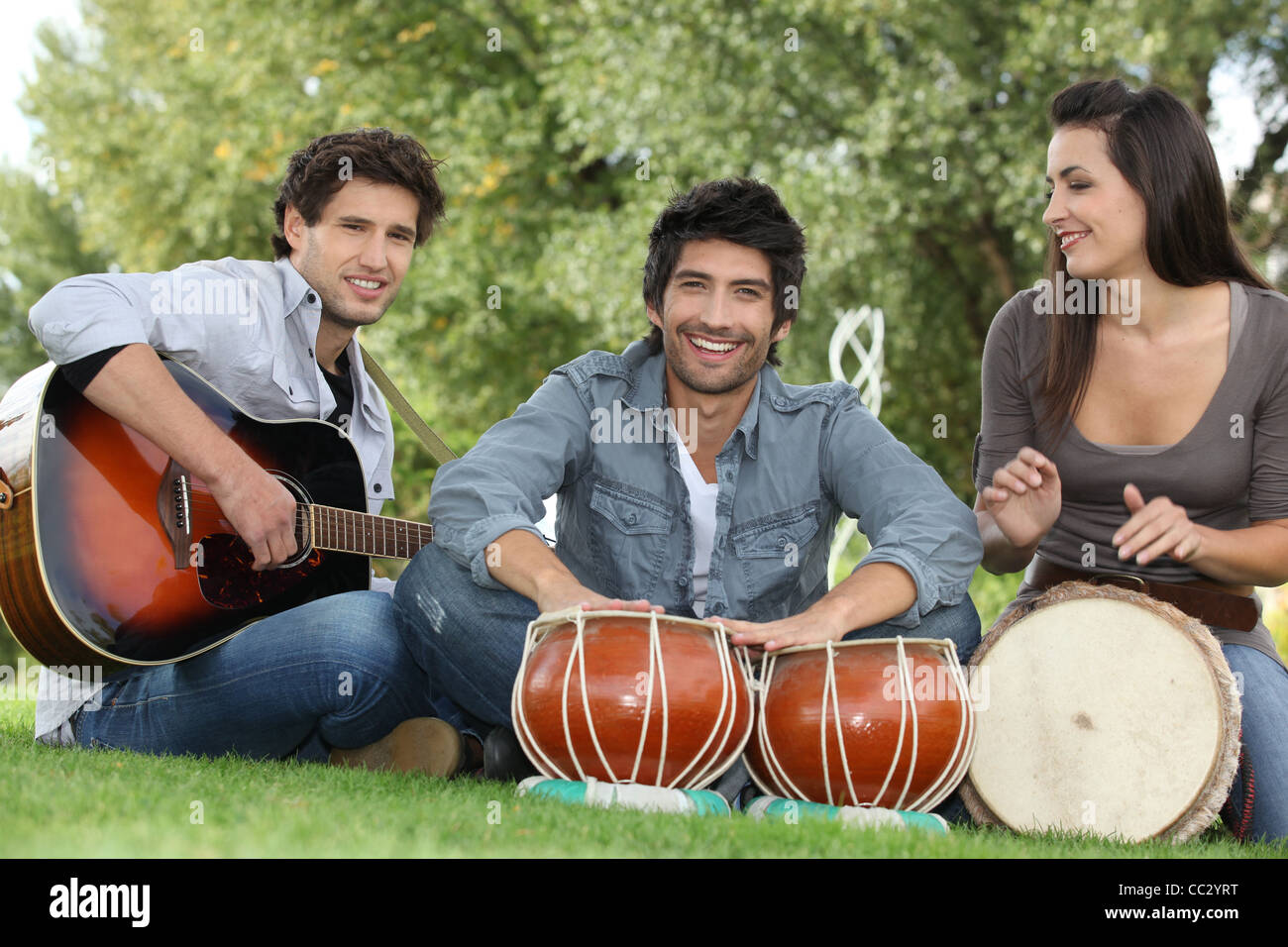 Three young musicians in park Stock Photo - Alamy