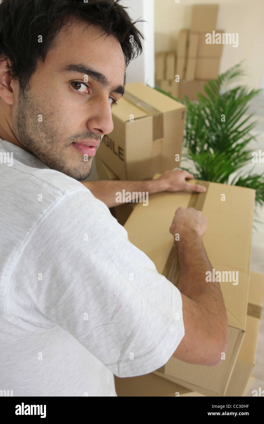 Young man packing boxes Stock Photo - Alamy