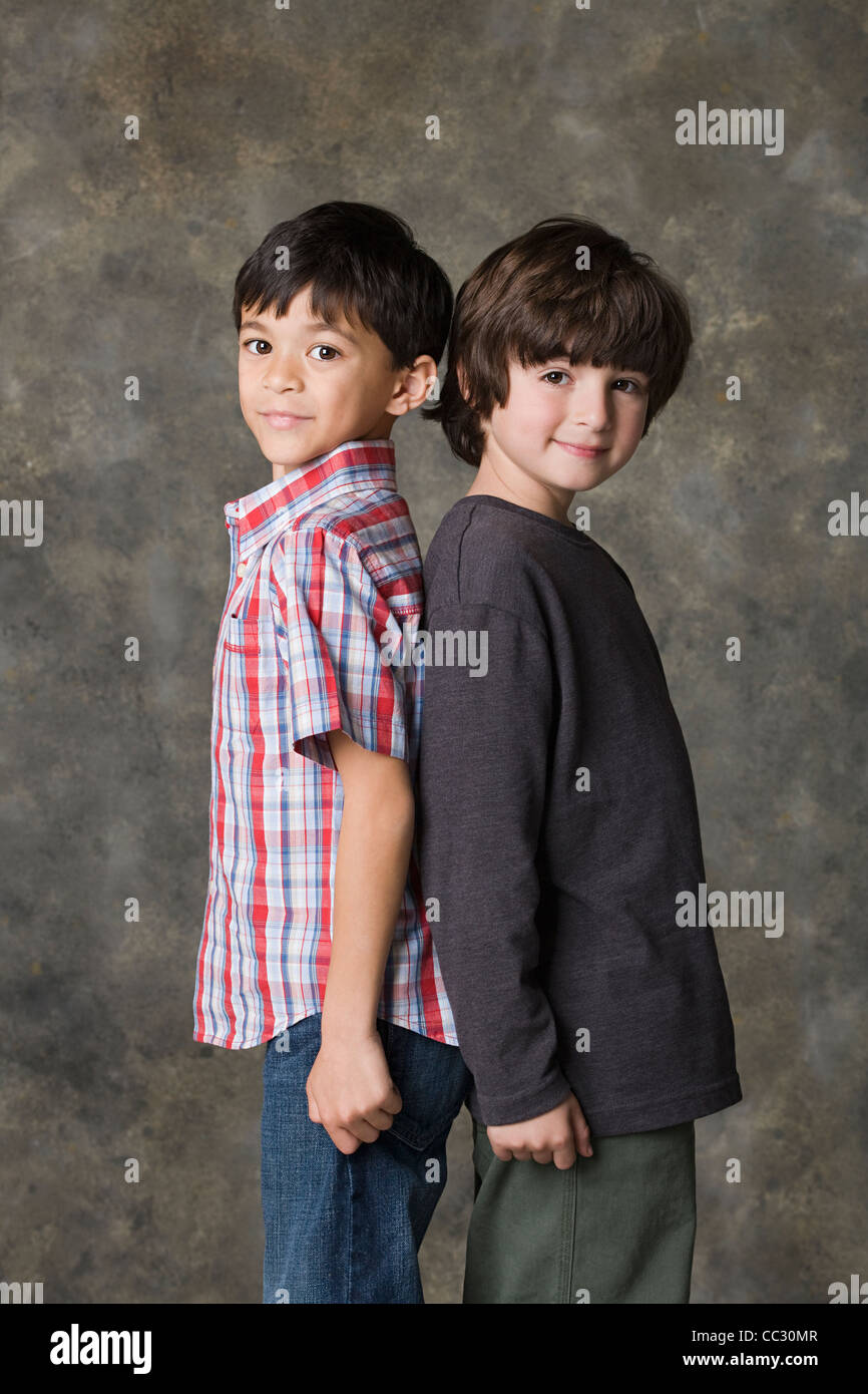 Two boys (6-7, 8-9) posing back to back, studio shot Stock Photo - Alamy