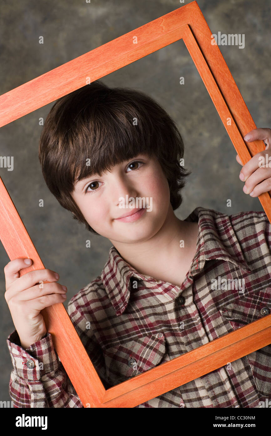 Portrait of boy (6-7) looking through frame, studio shot Stock Photo ...