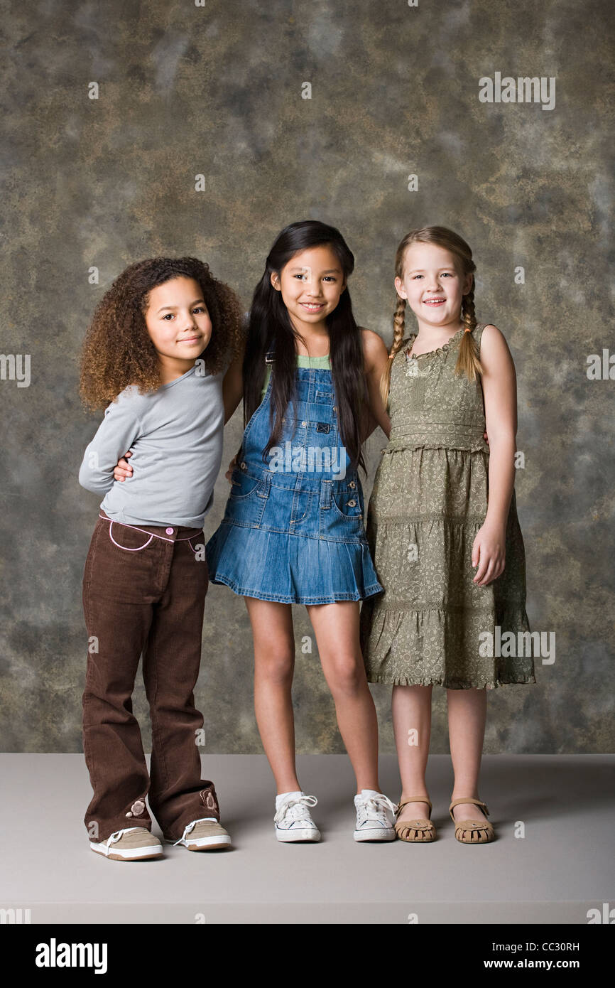 Three smiling girls (8-9) standing together, studio shot Stock Photo ...