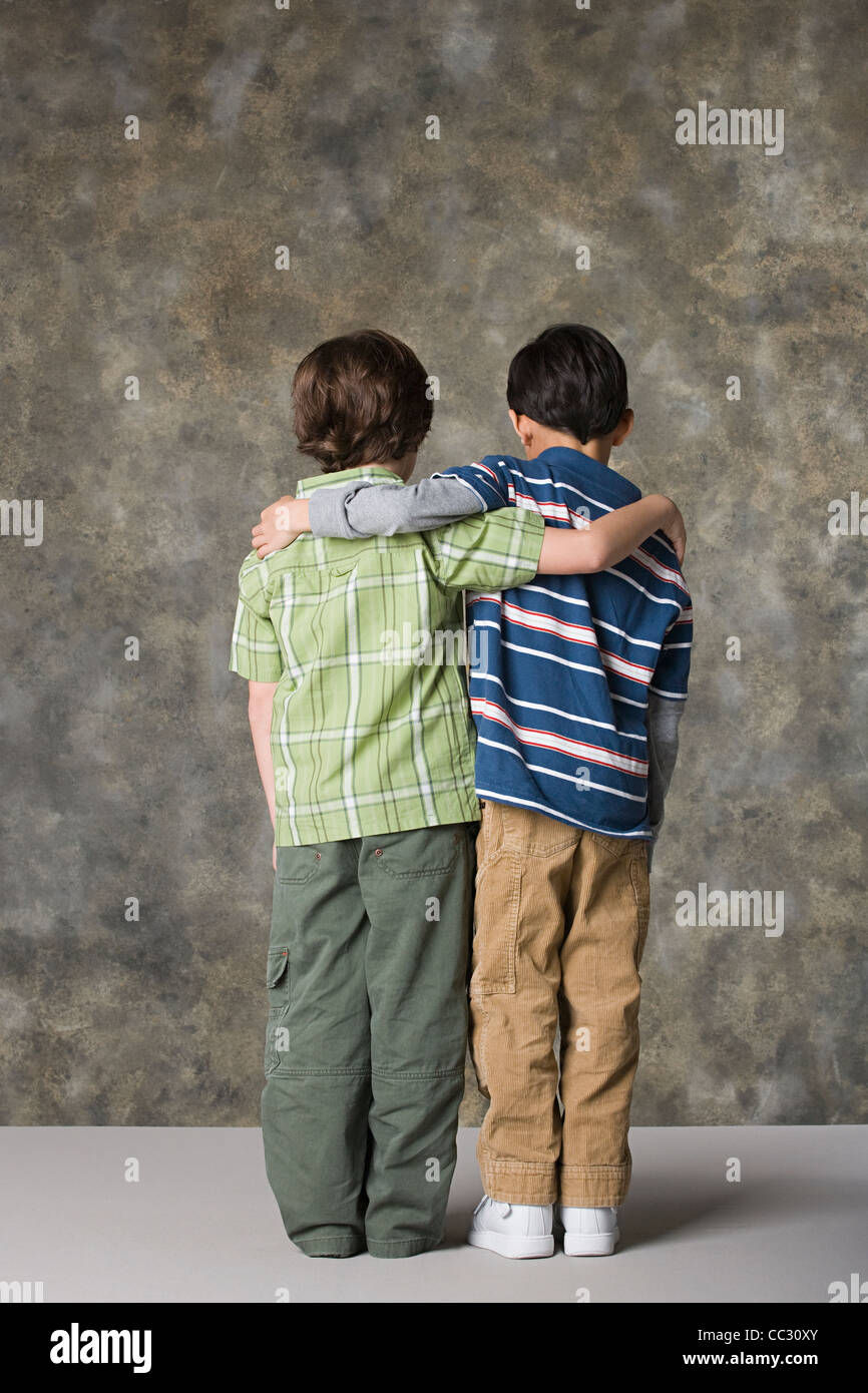 Rear view of two boys (6-7, 8-9) standing together, studio shot Stock ...