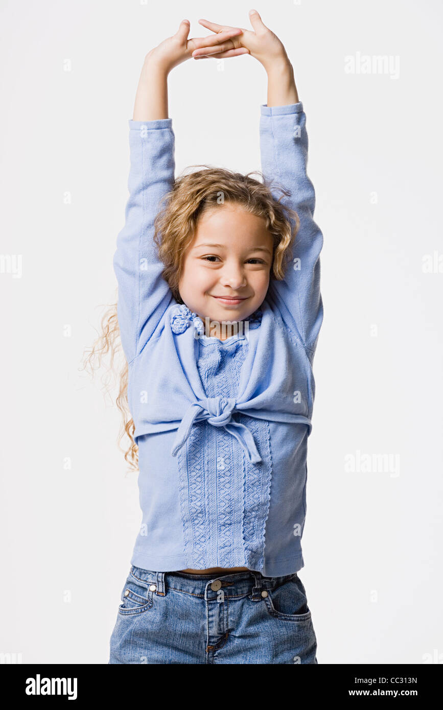 Studio portrait of smiling girl (8-9) with arms up Stock Photo - Alamy